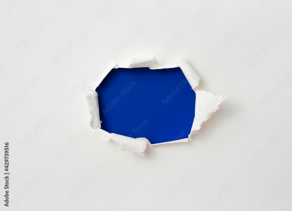 torn paper with the curled ripped sides. a round blue hole of torn on ...