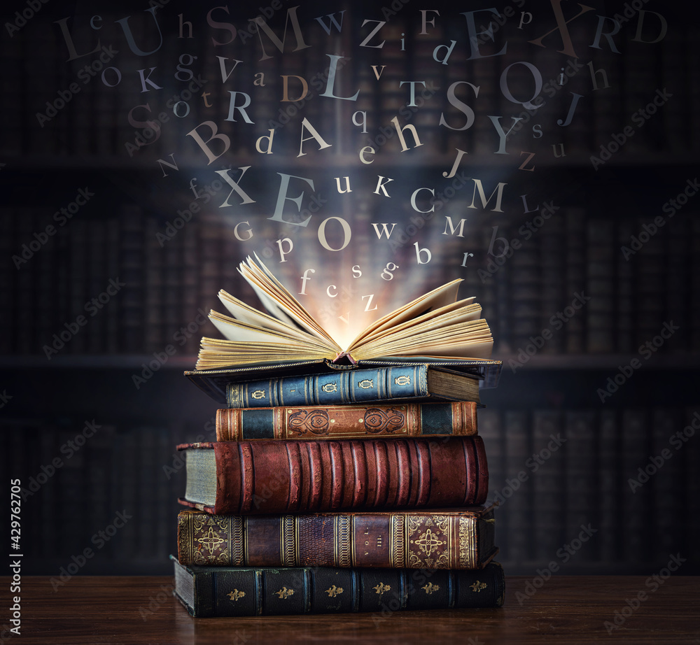 Old book with flying letters and magic light on bookshelf background in ...