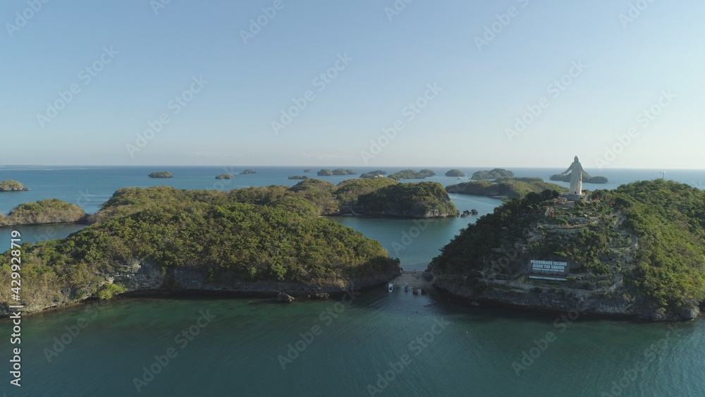 Small islands in Hundred Islands National Park with statue of Jesus ...