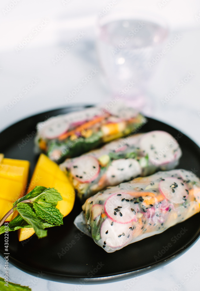 Colorful Viatnamese spring rolls with black sesame seeds, and mango on ...
