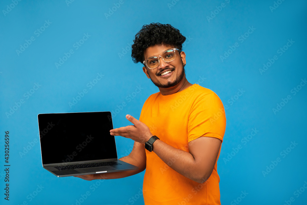 Handsome Indian guy on a blue background, studio photo, holding a ...