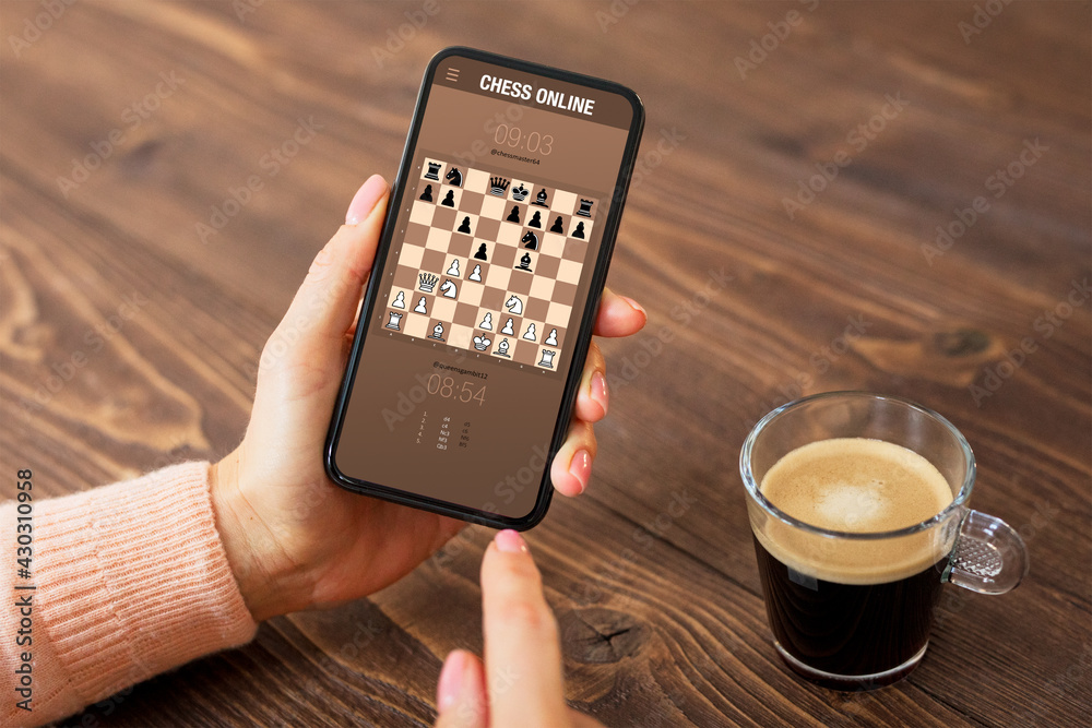 Foto de Stock Person playing chess online on mobile phone | Adobe Stock