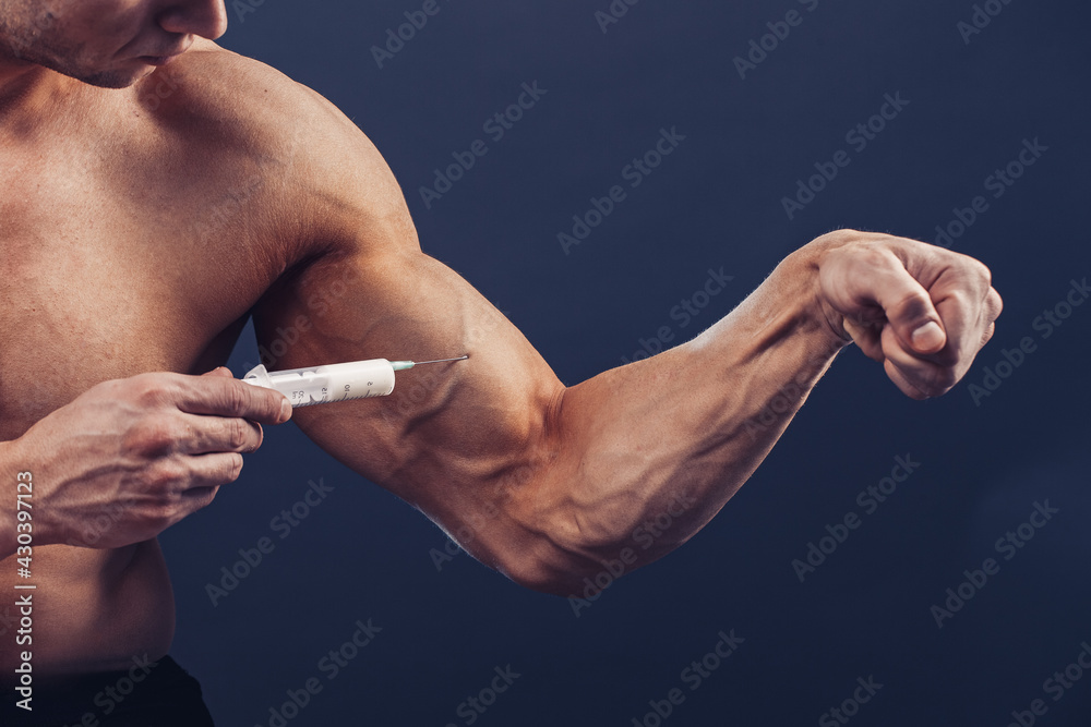 Bodybuilder makes injection of vitamins. Photo of sporty man with ...