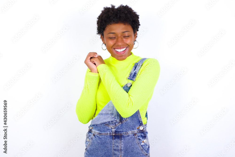 Dreamy young African American woman with short hair wearing denim ...