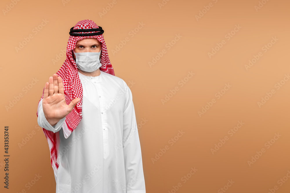 An Arab man in national dress shows a stop gesture with his hand ...