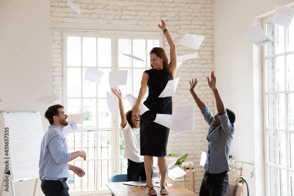 Foto de Stock Joyful young female team leader boss dancing on table ...
