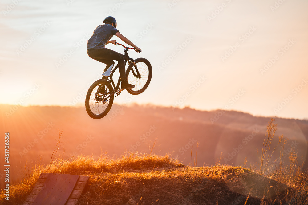 Young man flying through the air on a mountain bike Stock Photo Adobe Stock