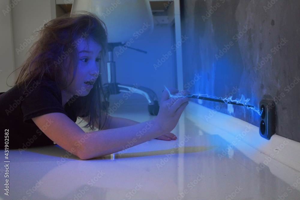 The little girl puts a wand in a socket. There is an electric discharge ...