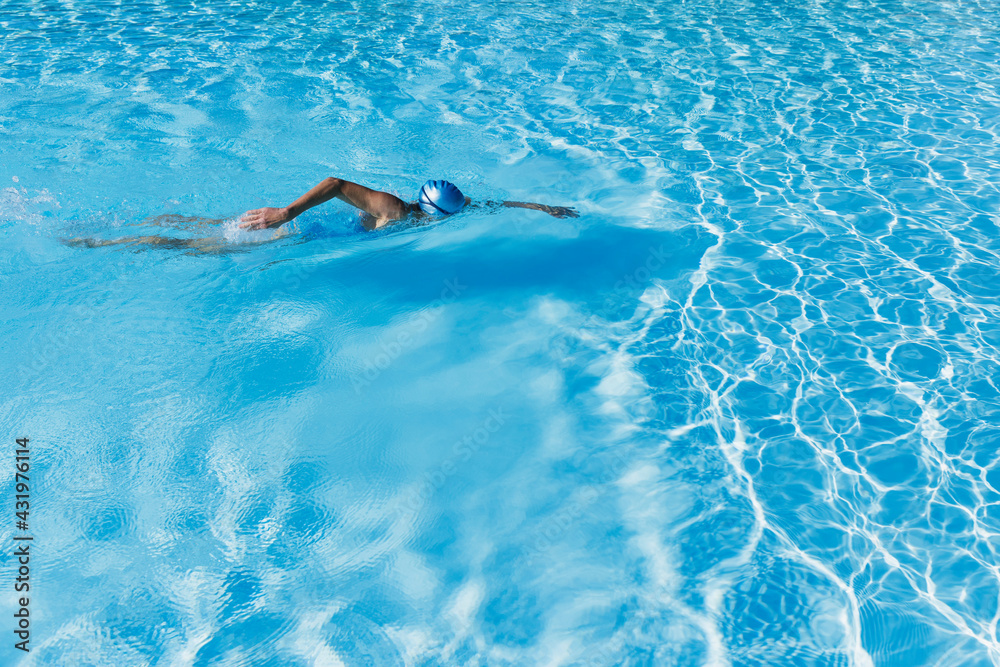 Woman swimming in clear blue swimming pool Stock Photo | Adobe Stock