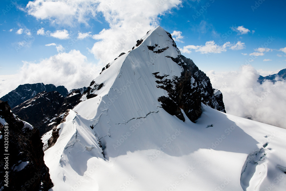 Climbers descend the steep pyramid from the glacier-covered summit of ...