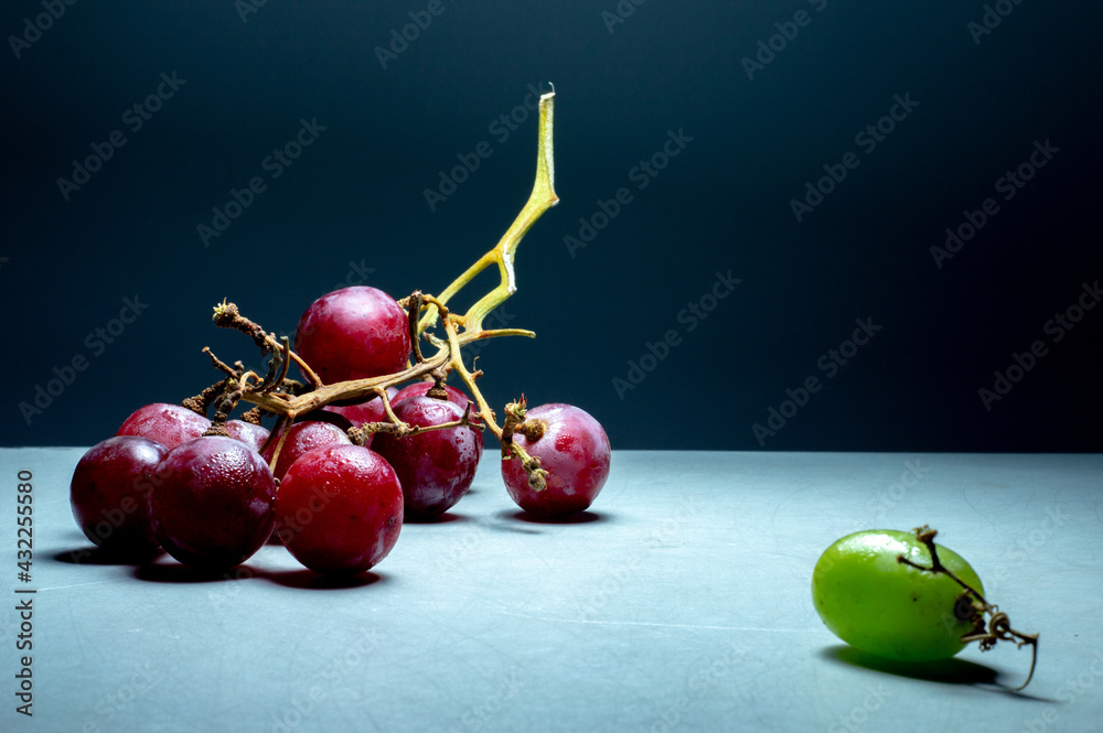 Foto de Stock Racimo de uvas rojas y una uva verde asilada, idea de ...