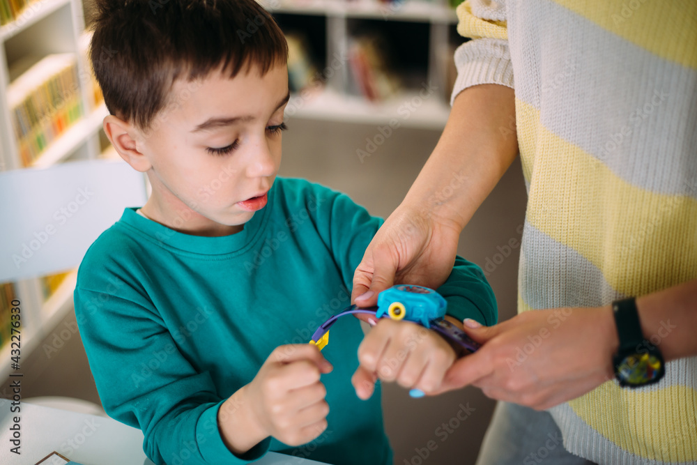 Mom gives her son his first watch. Learning to determine the time by ...