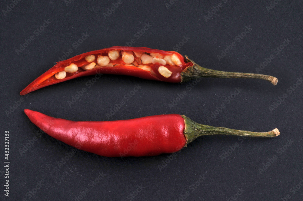 Piment rouge entier et piment rouge coupé sur fond noir Stock Photo ...