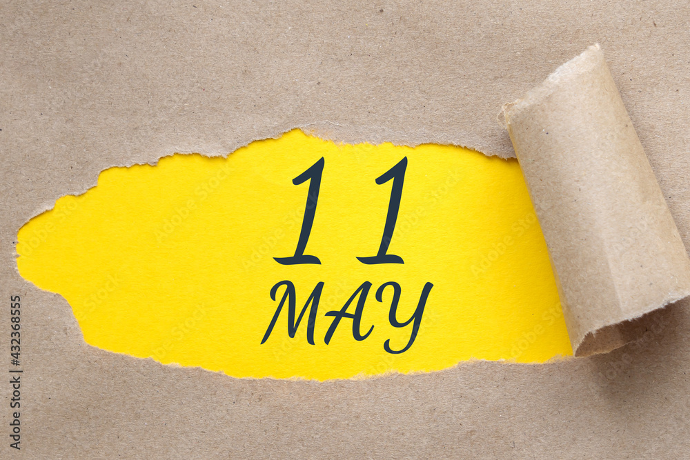 may 11. 11th day of the month, calendar date. Hole in paper with edges ...