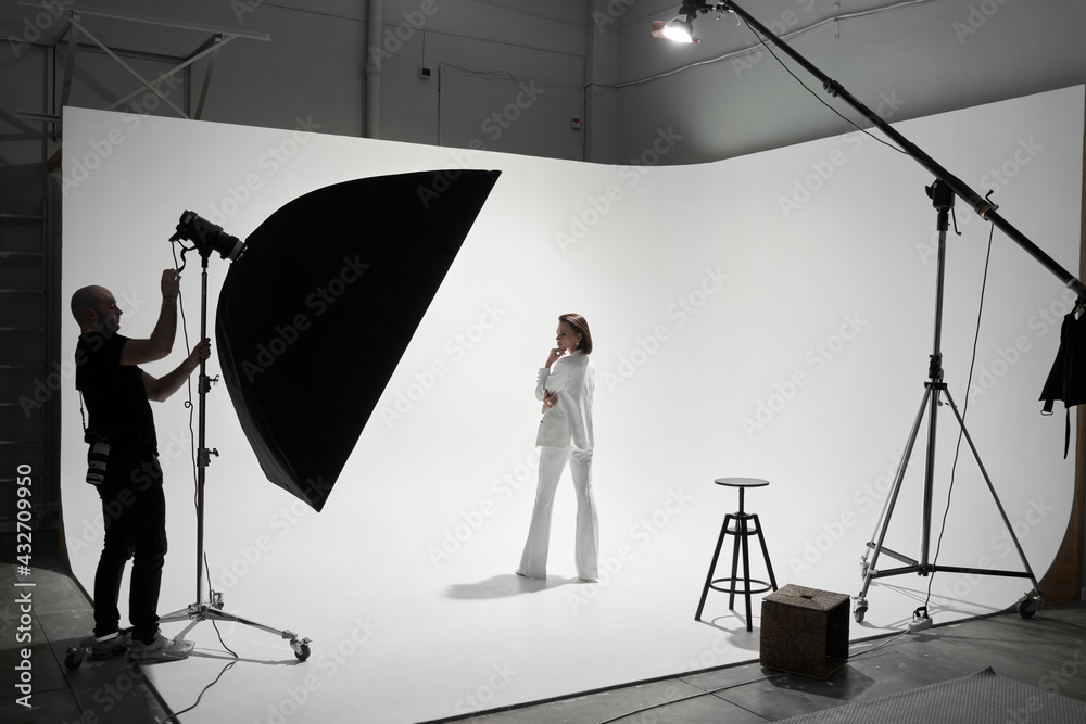 Fashion photography in a photo studio. Professional male photographer ...
