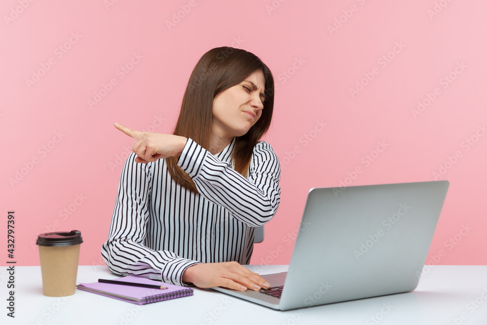 Irritated bossy business woman sitting at workplace and pointing finger ...