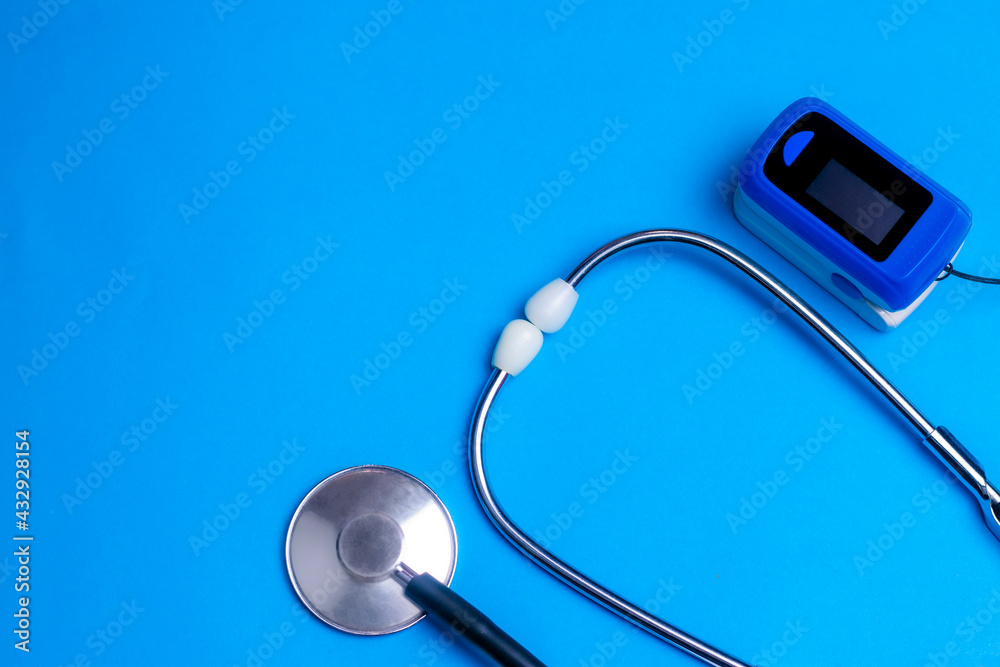 Stethoscope and pulse oximetry on blue background. Pulse oximetry a ...