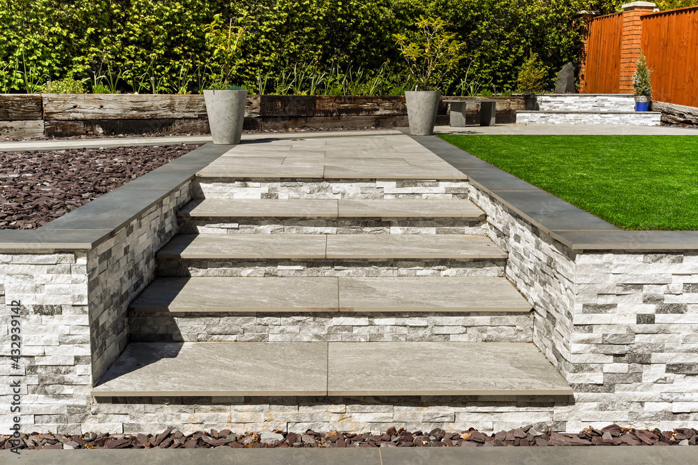 Steps in a residential back garden landscaped with light and dark grey ...