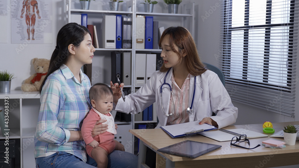 japanese mother gently touch her daughter’s head while describing about ...