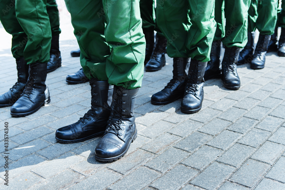 Soldiers in leather boots and green uniforms. Formation of the army ...