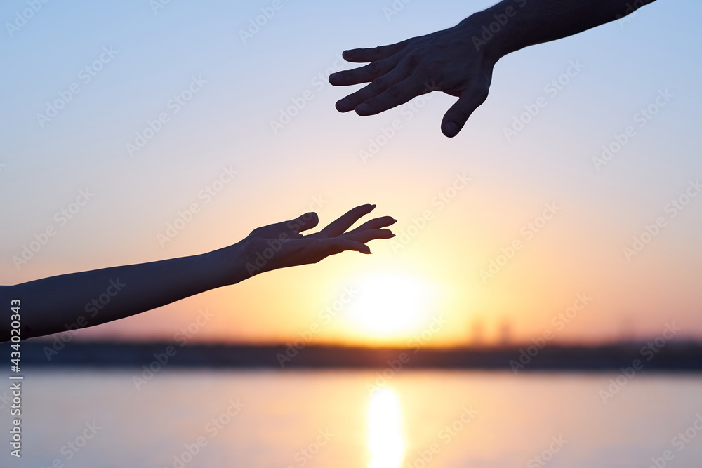 Giving a helping hand. Silhouette Two hands, man and woman, reaching ...