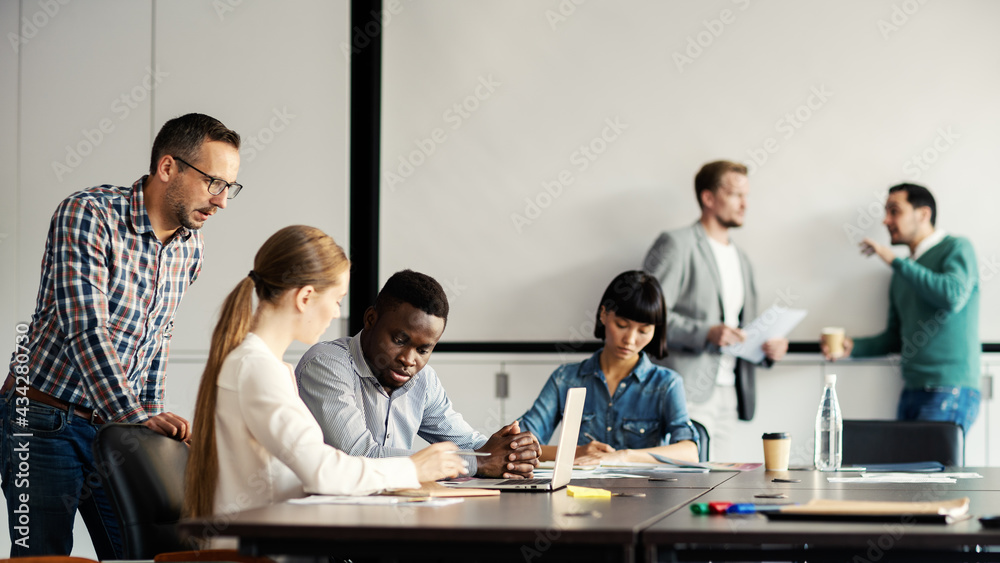 Team of diverse business people having meeting in conference room ...