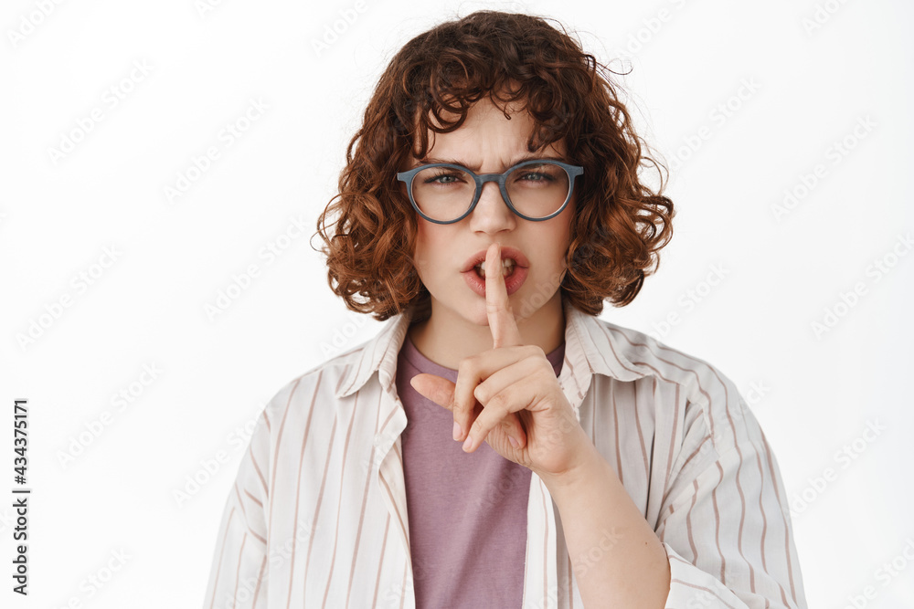 Angry student girl in glasses shushing, shut up quiet gesture, press ...
