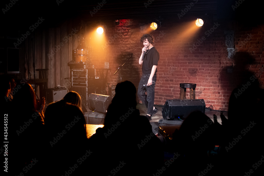 Young Caucasian male comedian performing his stand-up monologue on a ...