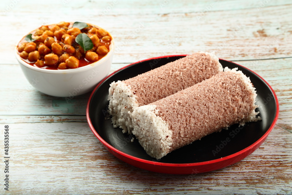 Homemade delicious steamed red rice puttu served with chickpeas curry ...