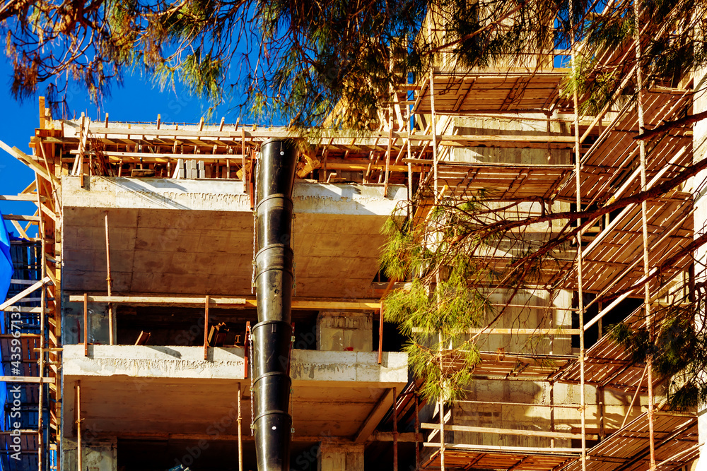 Suspended sections of black garbage chute on a facade of building under ...