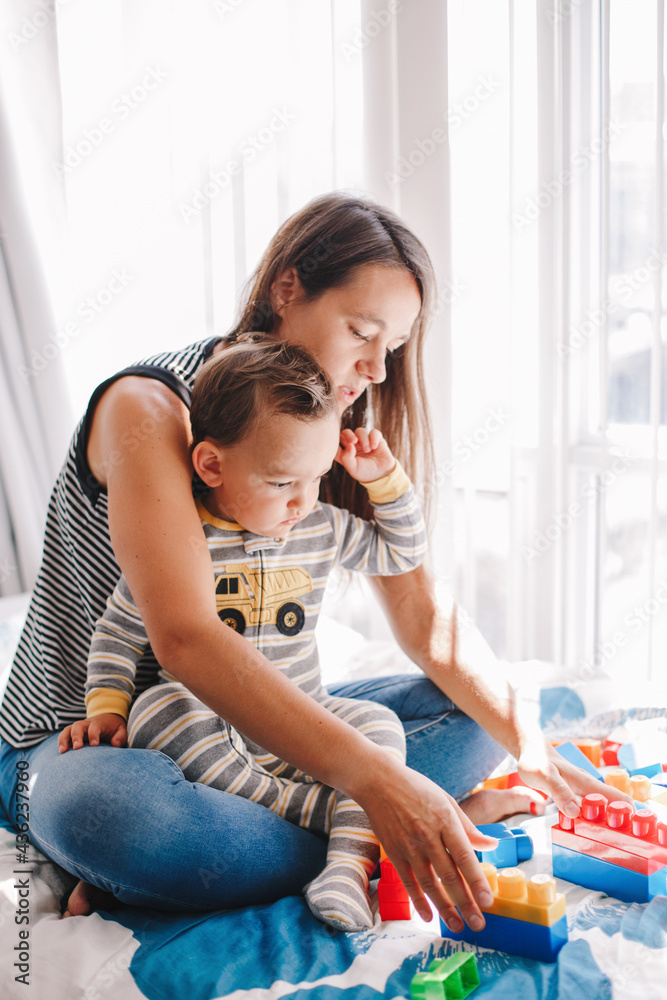Mother and baby toddler playing learning toy stacking building blocks ...