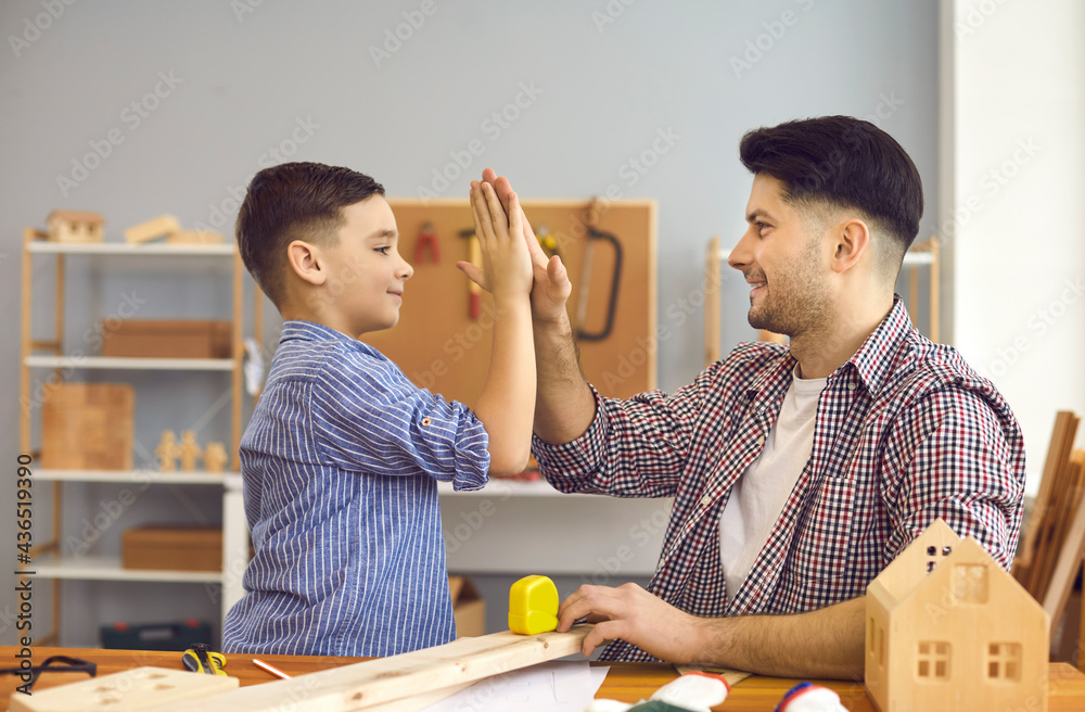 Happy smiling father giving high five and support to cheerful son after ...