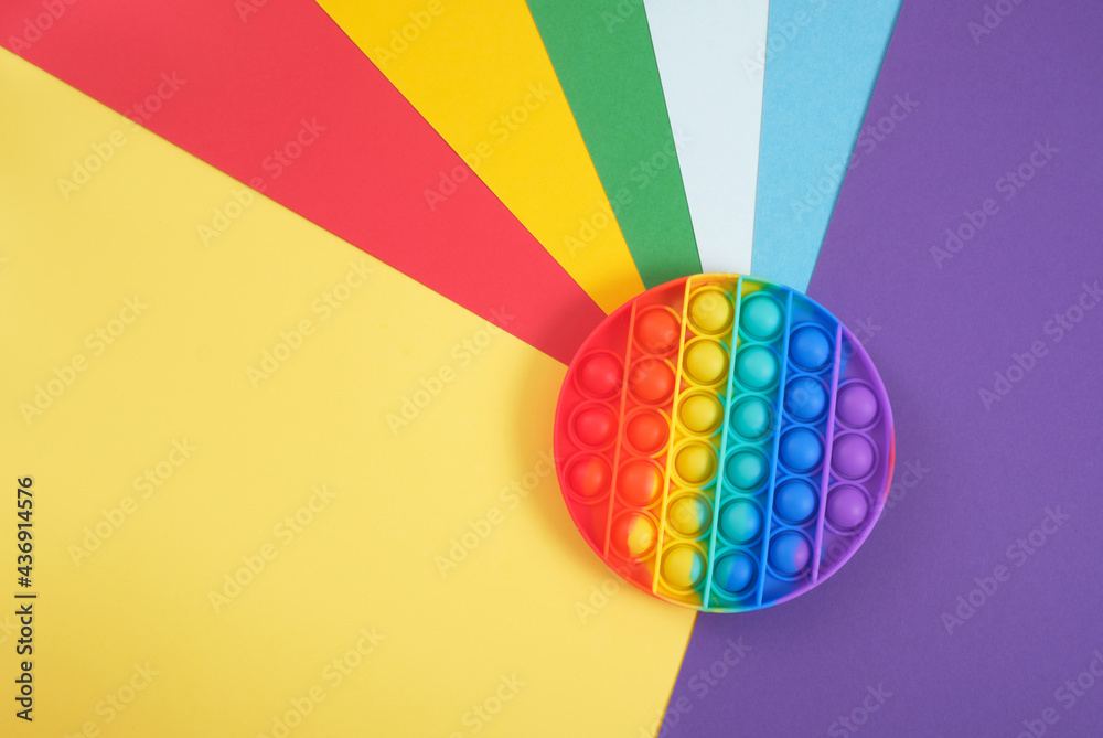 toy antistress pop it on a rainbow background, fidget toy, popping ...