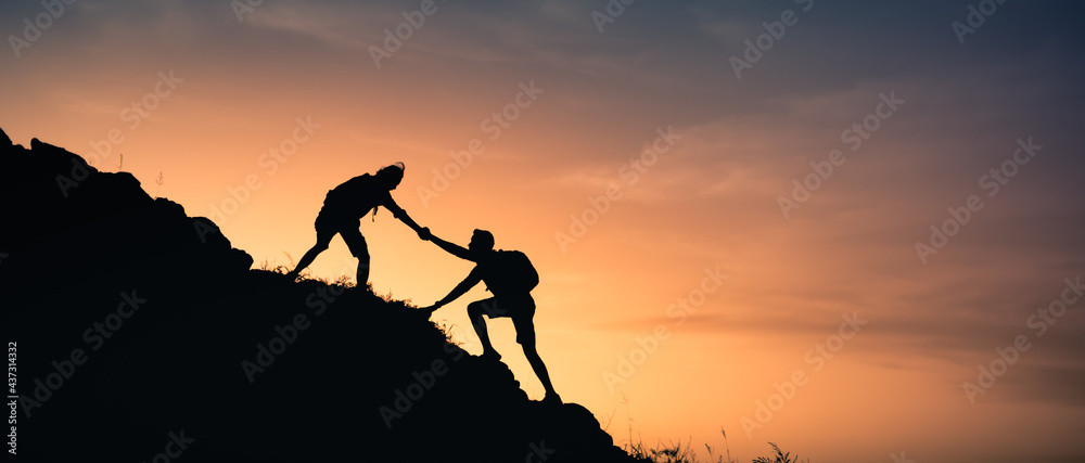 Hikers climbing a mountain giving a helping hand up the cliff. Teamwork ...