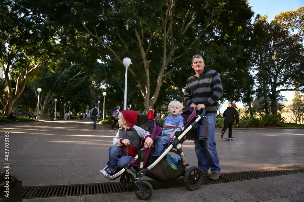 Father pushing two little boys in double pram while exploring Hyde Park ...