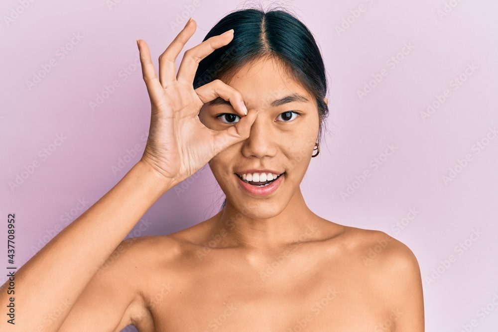 Young chinese woman standing topless showing skin doing ok gesture with ...