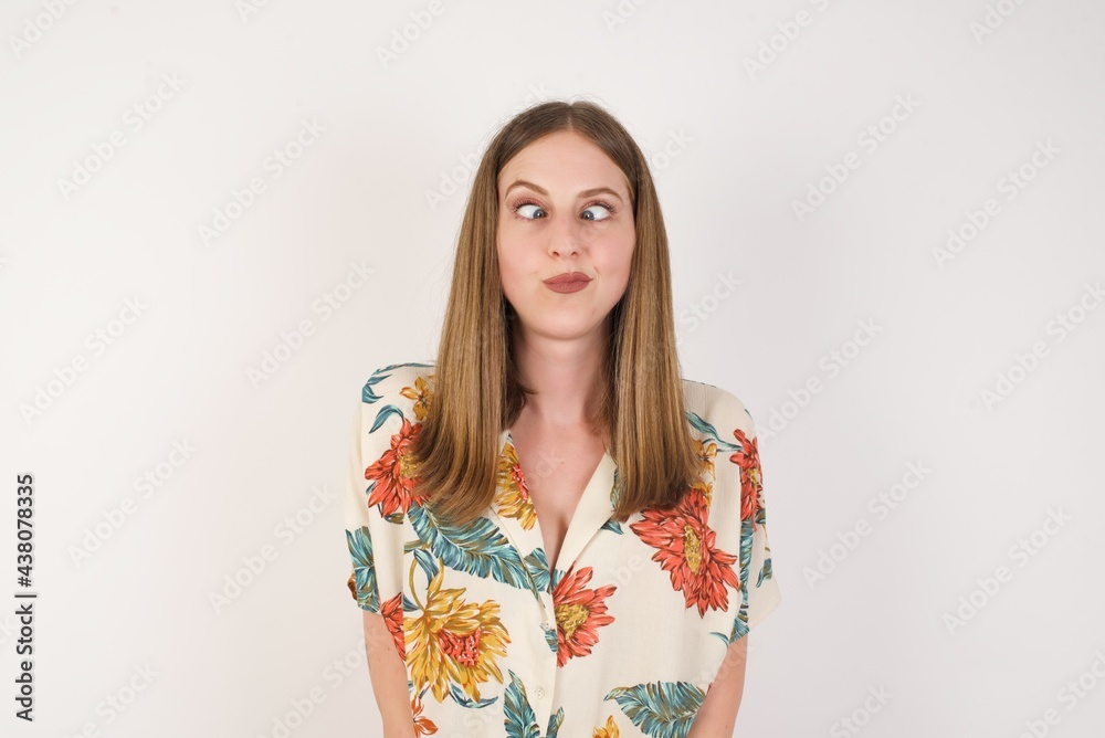 Funny comic girl crosses eyes, puts lips, makes grimace, foolishes ...