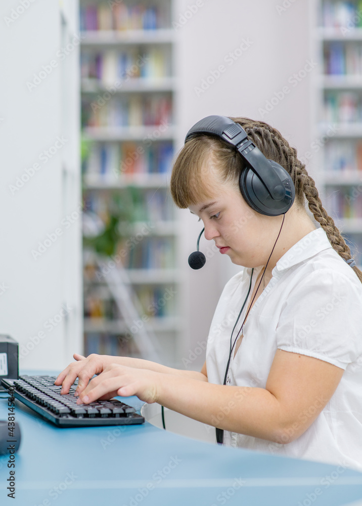 Young girl with syndrome down uses computer at school. Education for ...