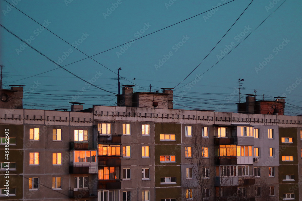 windows reflecting the sunset sky, soviet building, wires on the sky ...
