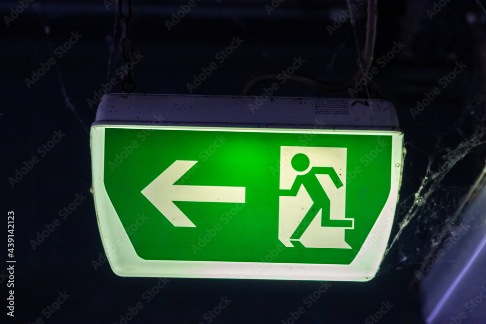 Green exit sign with running person and green arrow shows guidance ...