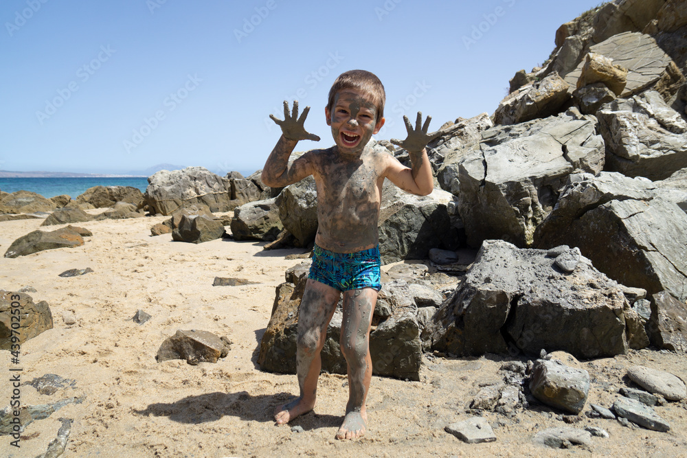 Child with the body slathered in mud on a beach Stock Photo | Adobe Stock