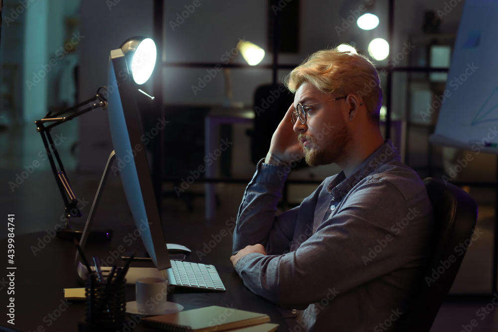 Handsome man working in office at night Stock Photo | Adobe Stock