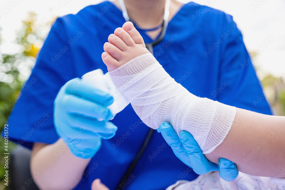 Doctor Rewinds Leg of Small Girl with Bandage. kid's foot was treated ...
