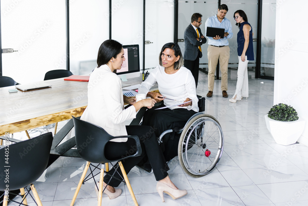 Latina disabled mature transgender woman pointing at document with ...
