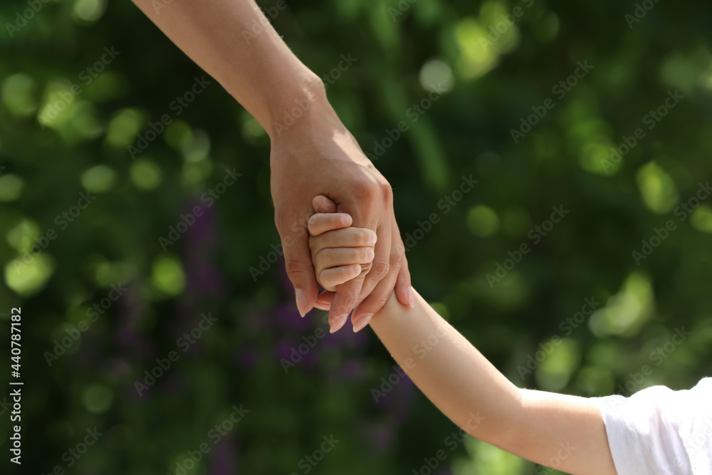 Mom and her child holding hands in park, closeup Stock Photo | Adobe Stock