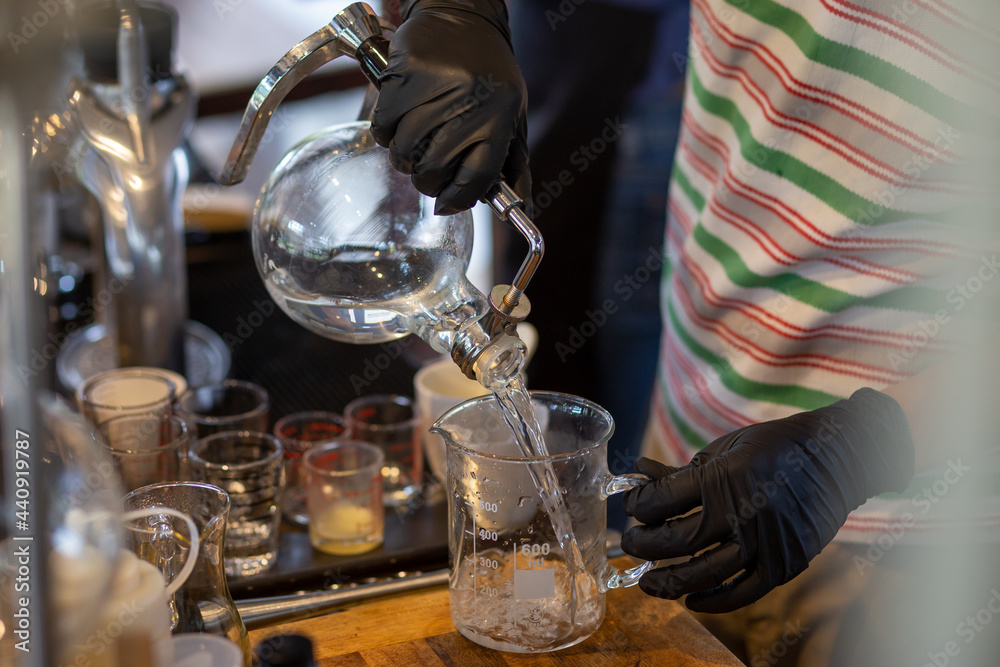 Select the focus glass container after distillation people pouring ...