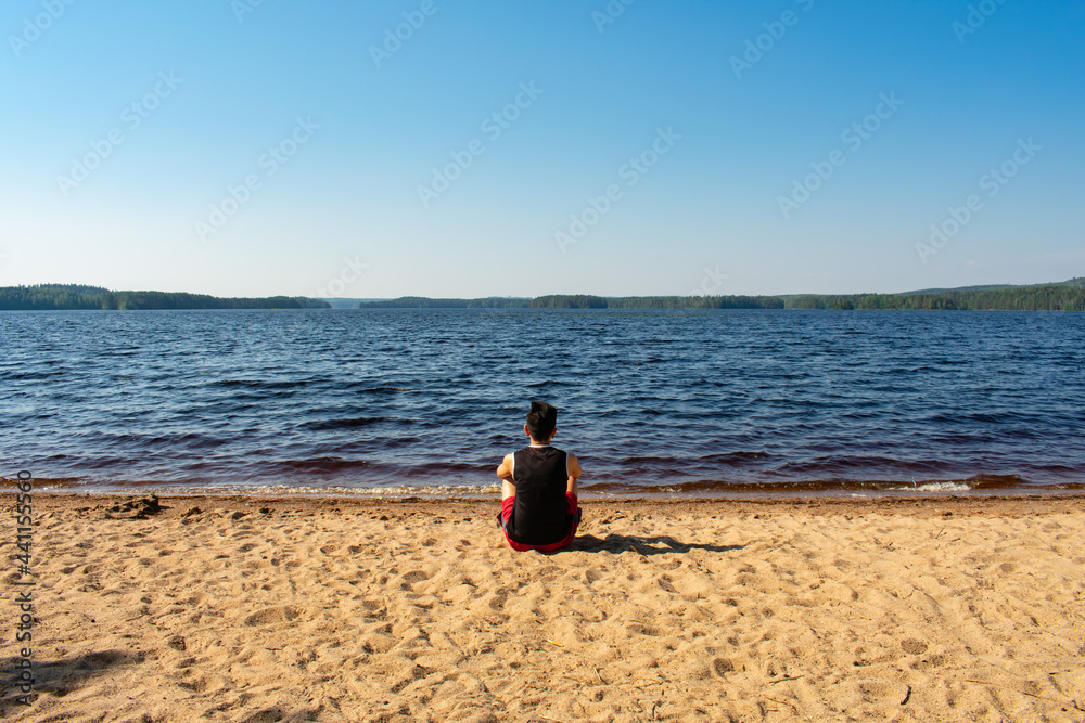 Asian LGBTQ Alone on the Shore. An asian LGBTQ member sitting on the ...