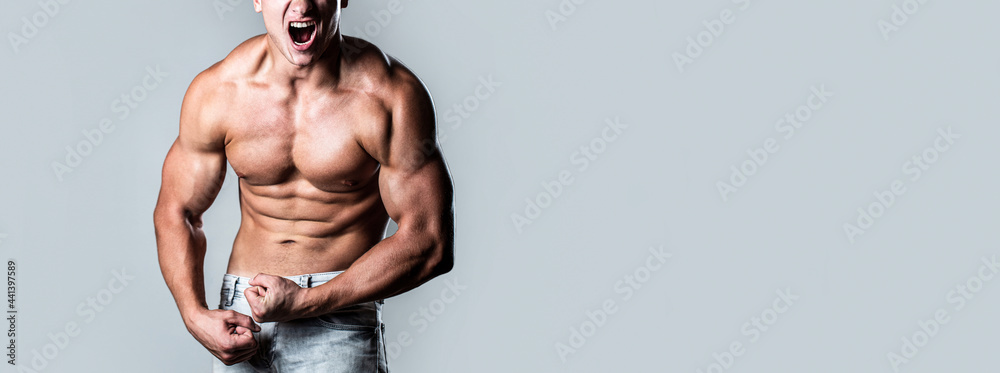 Muscular male strains muscles and screams. Muscular bodybuilder posing ...
