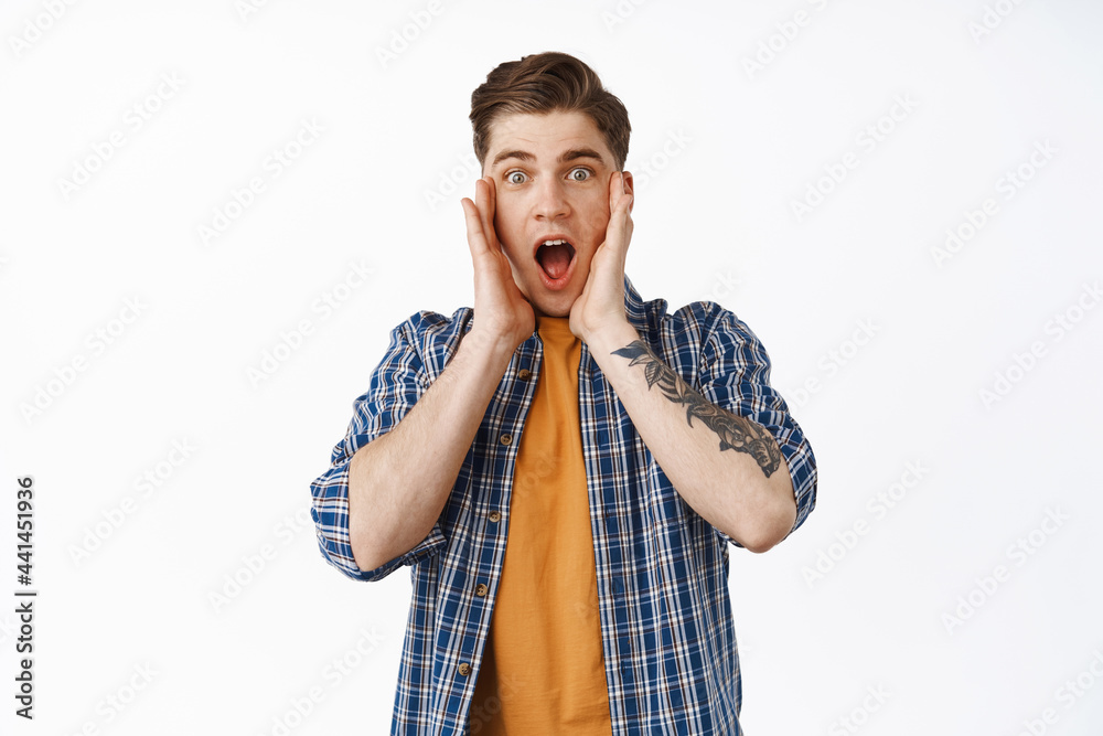 Omg shock. Astonished and surprised young man gasping, say wow, touch ...