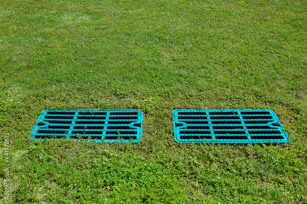 Foto de Stock manhole drainage grates on the lawn with green grass ...